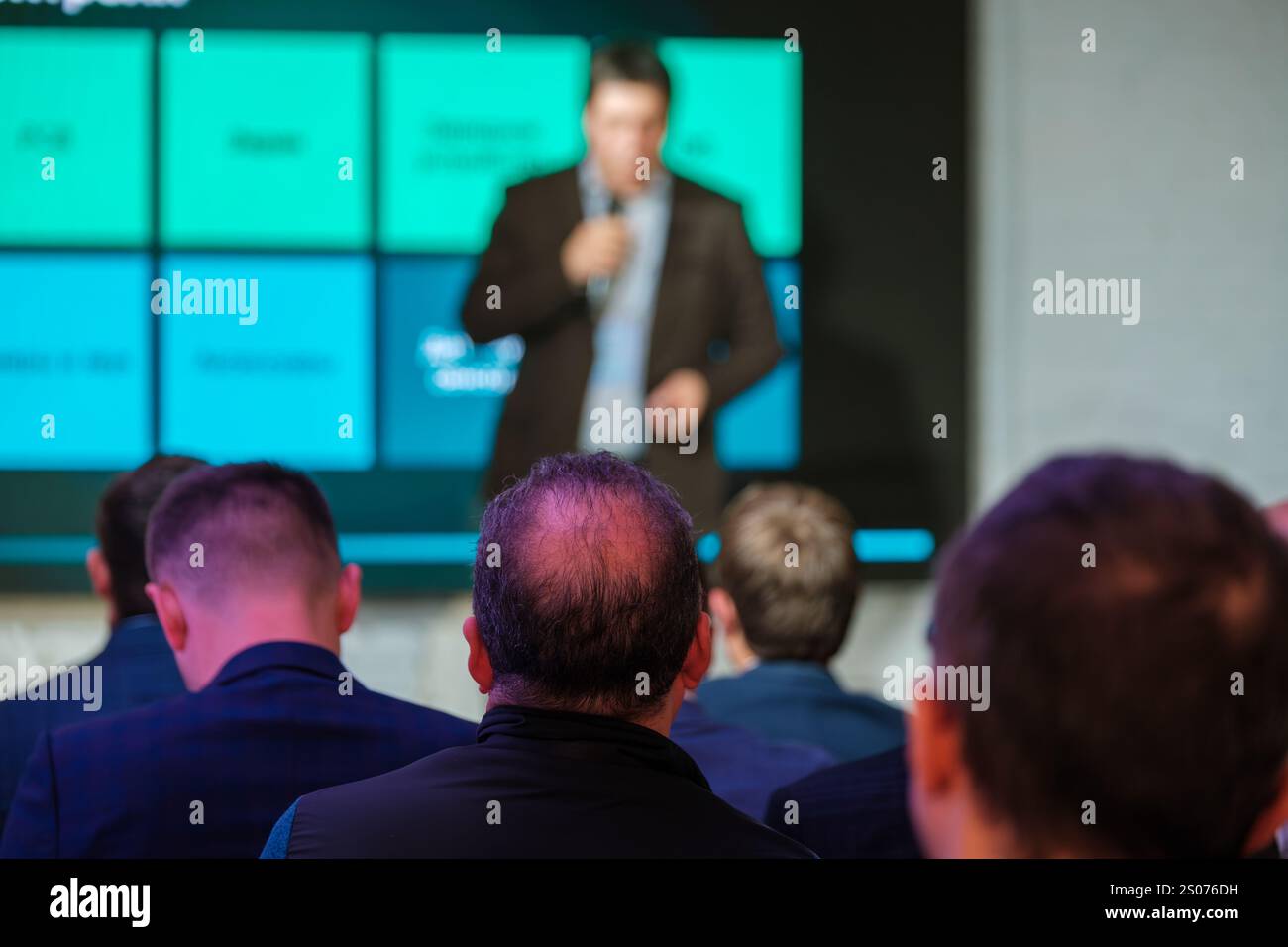 Professional audience engaged with speaker during business presentation in modern conference ...