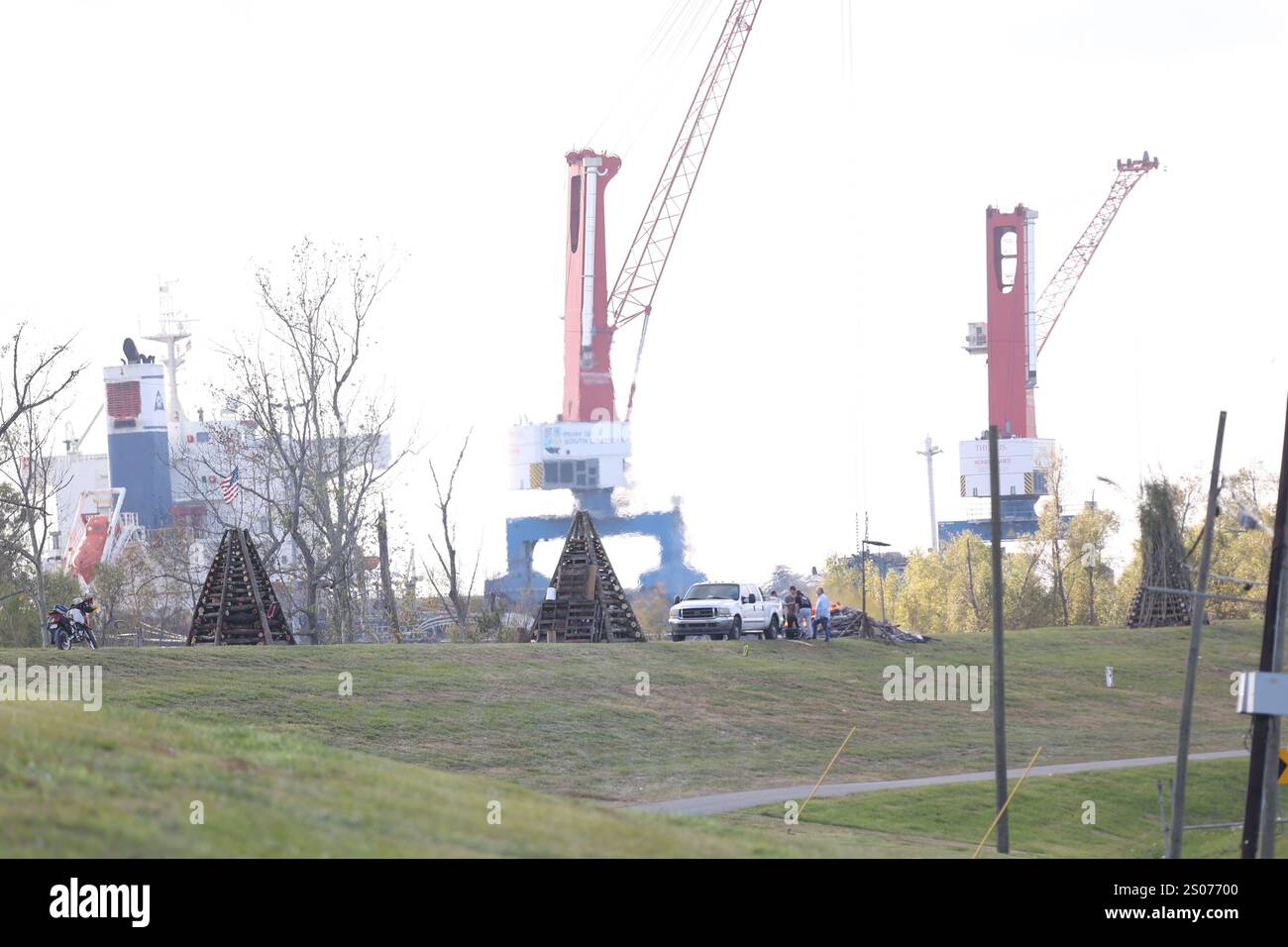 A trio of bonfires with some Port of South Louisiana cranes in the ...