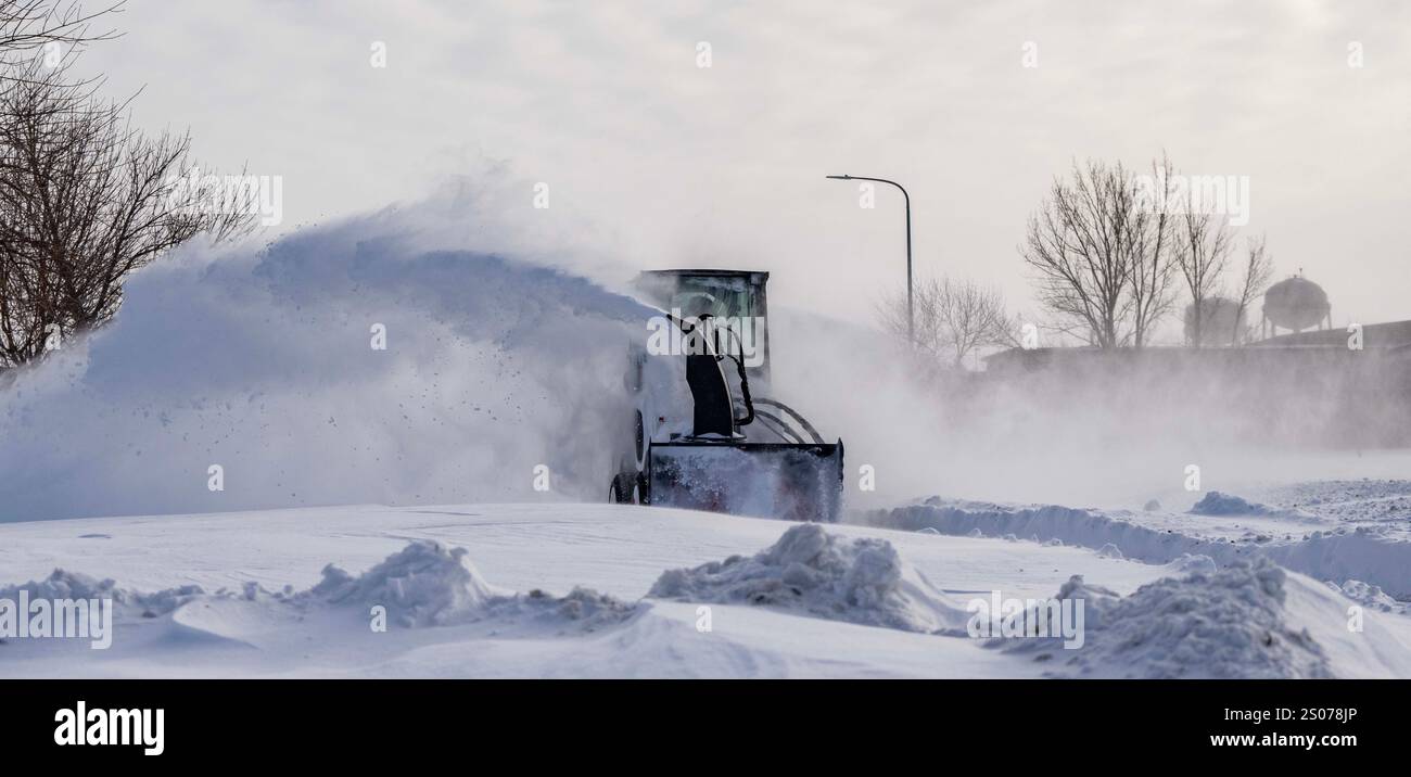 A civilian assigned to the 5th Civil Engineer Squadron (5 CES) plows ...