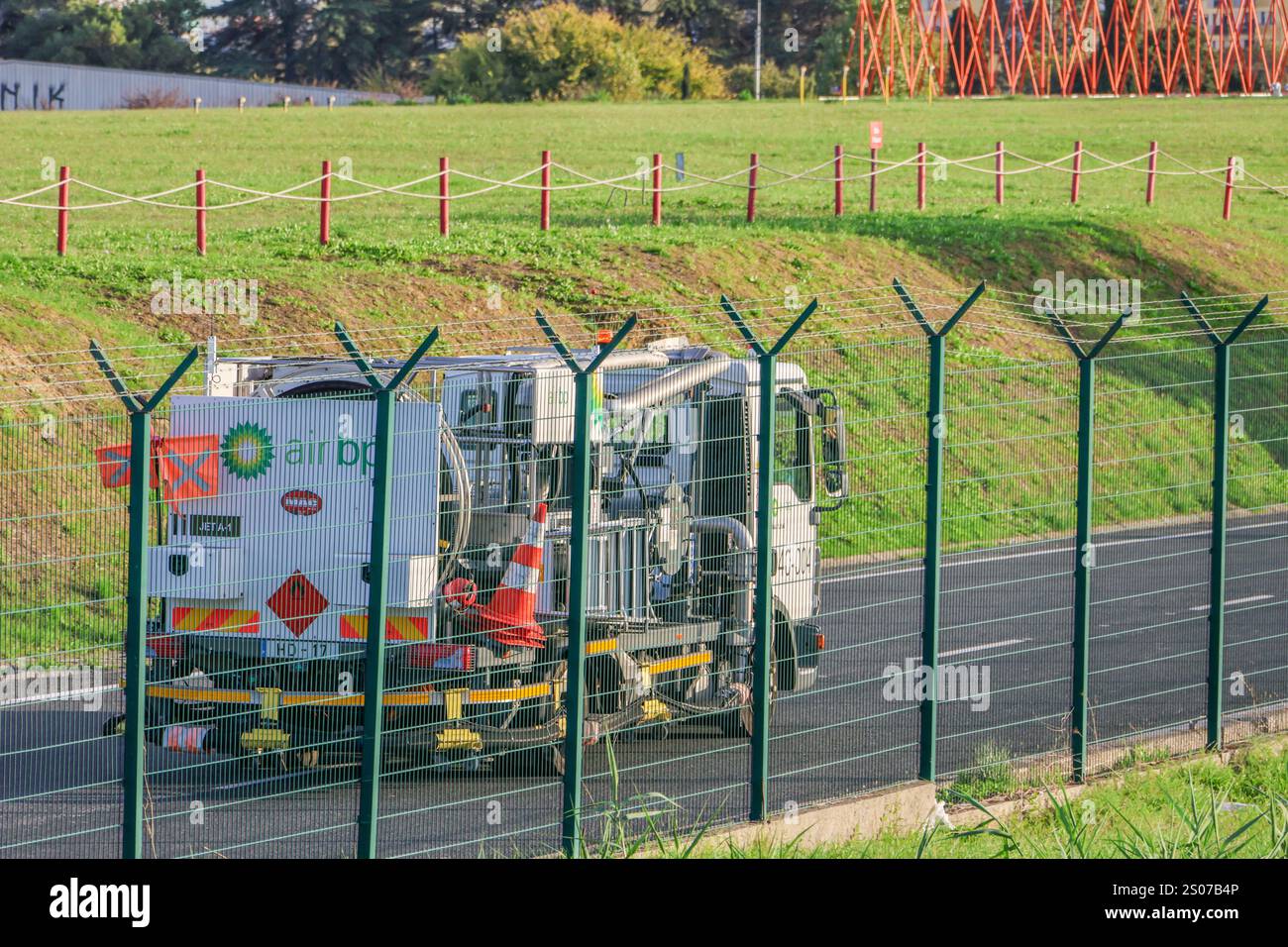 Air bp fuel tanker truck driving on a road next to a green fence at ...