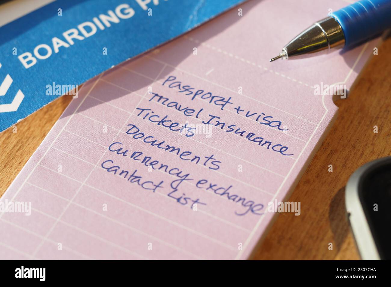 Travel Checklist Next to Boarding Pass and Pen on Wooden Surface Stock ...