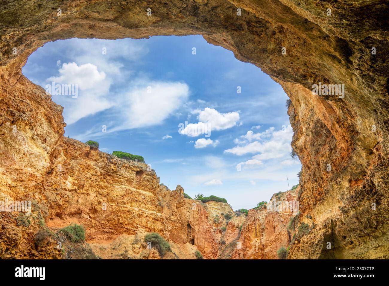 A stunning coastal cave with rugged rock formations and a clear blue ...