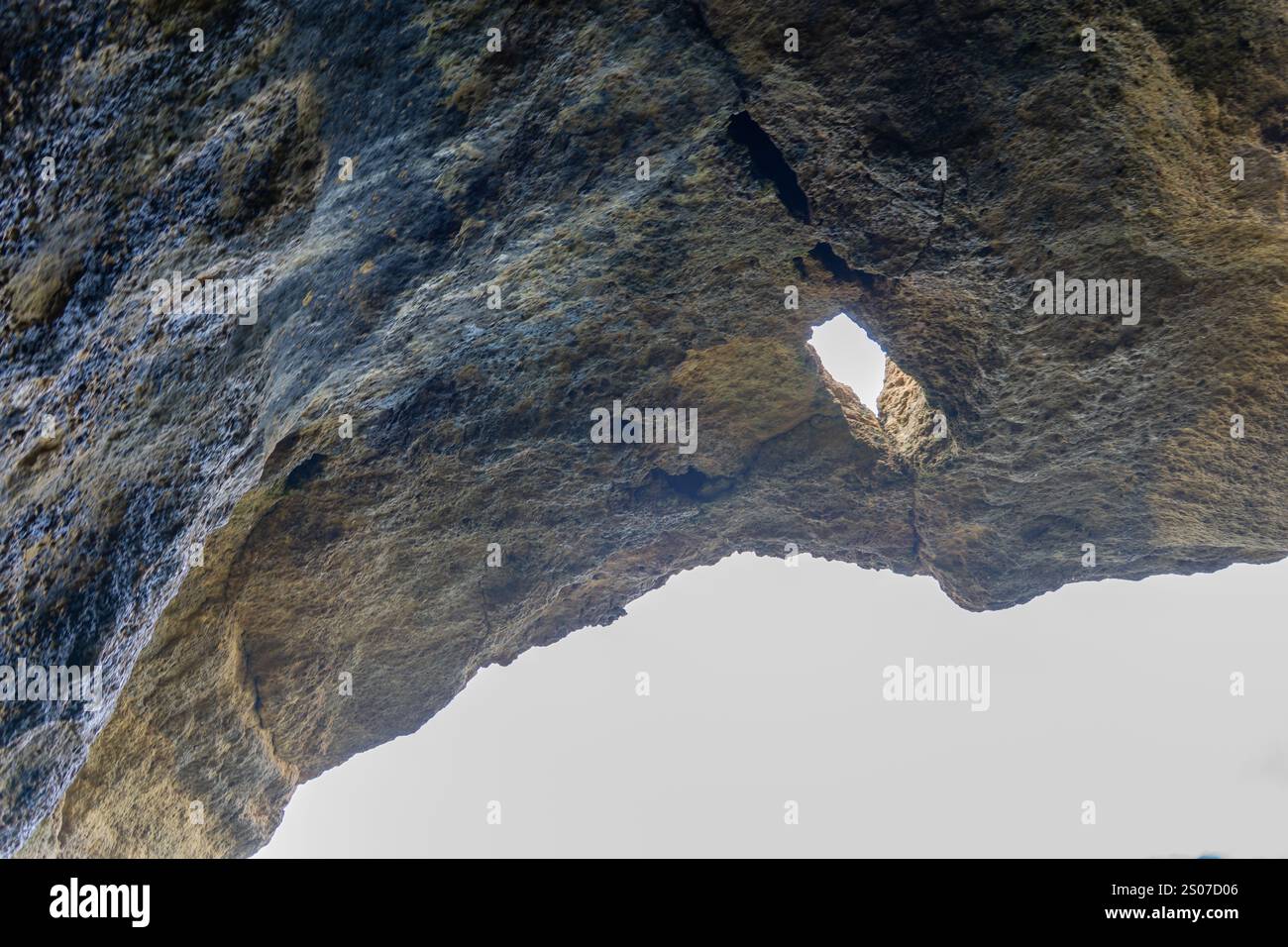 A beam of sunlight shines through a narrow opening in the ceiling of a ...