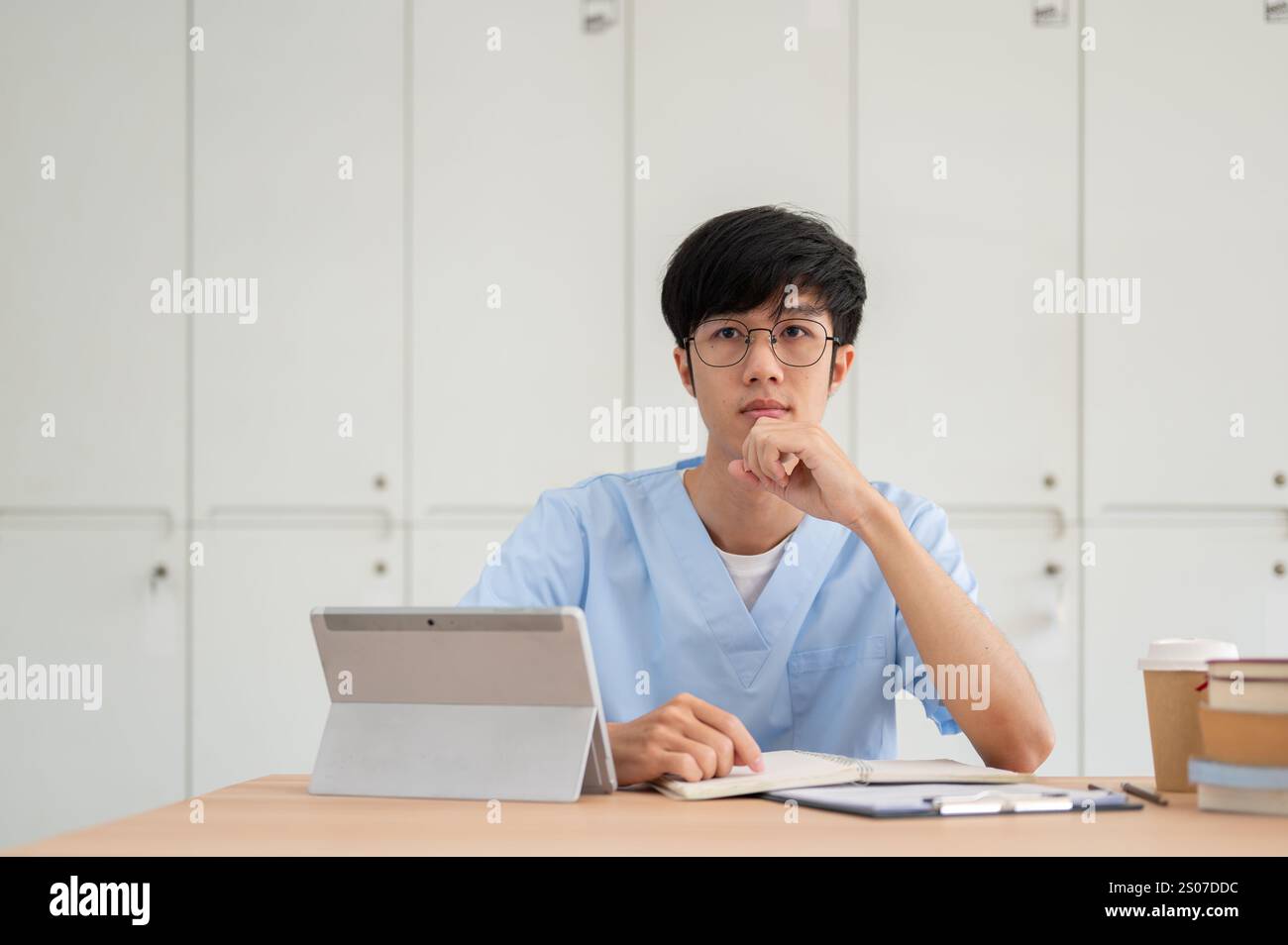 A smart Asian male medical student in scrubs, wearing eyeglasses, is ...
