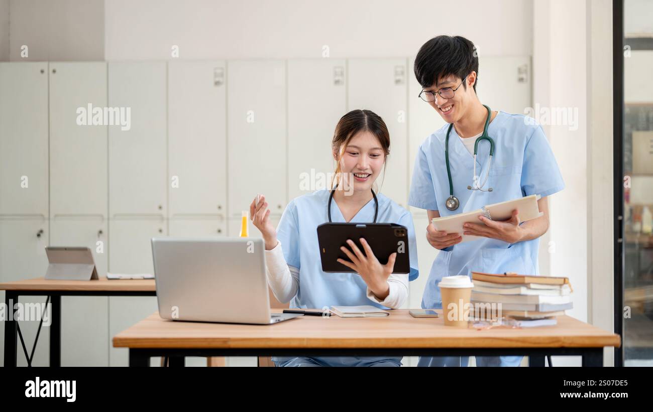 Smart Asian female and male medical students in scrubs are discussing ...