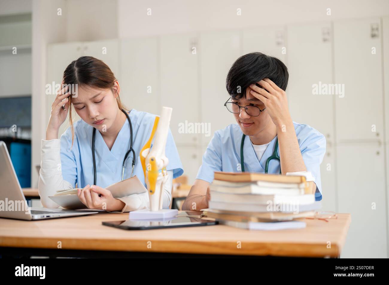 Two stressed and concerned Asian medical students are focused on ...