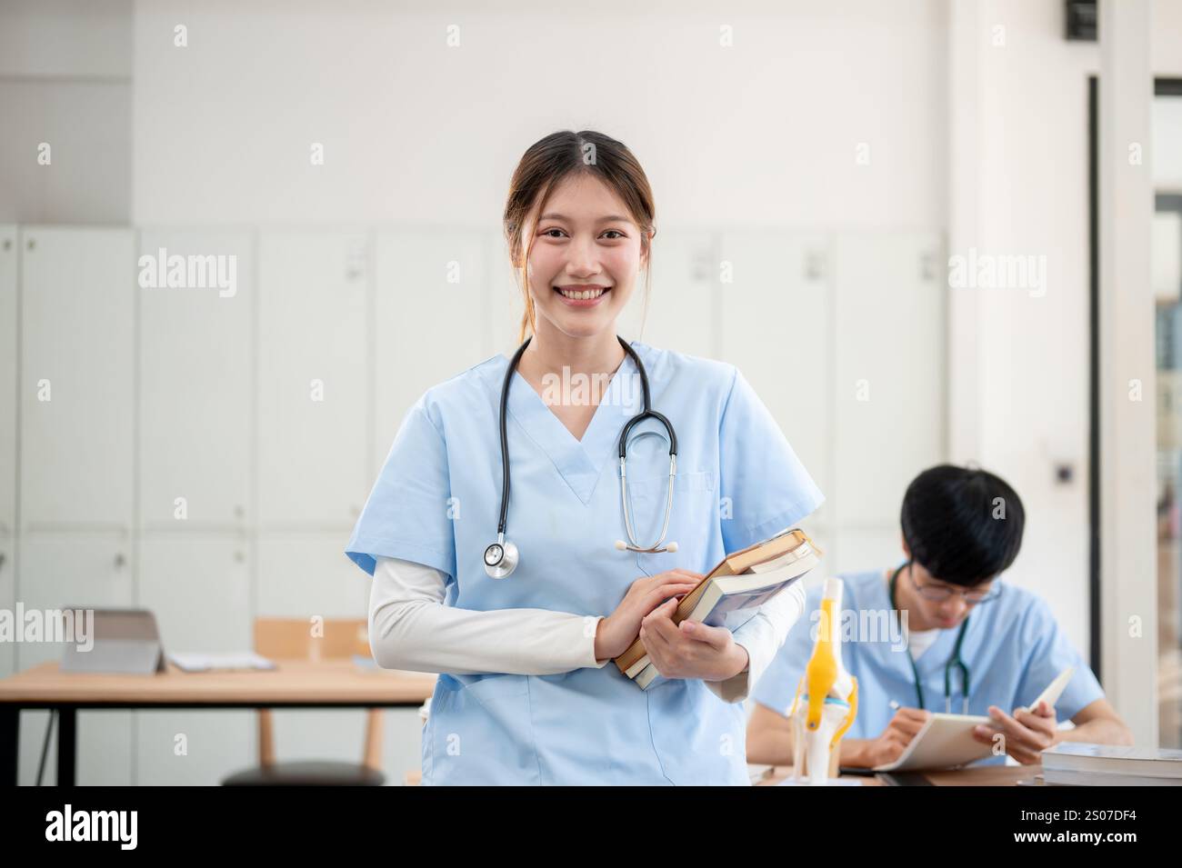 A portrait of a beautiful, smart Asian female medical student in scrubs ...