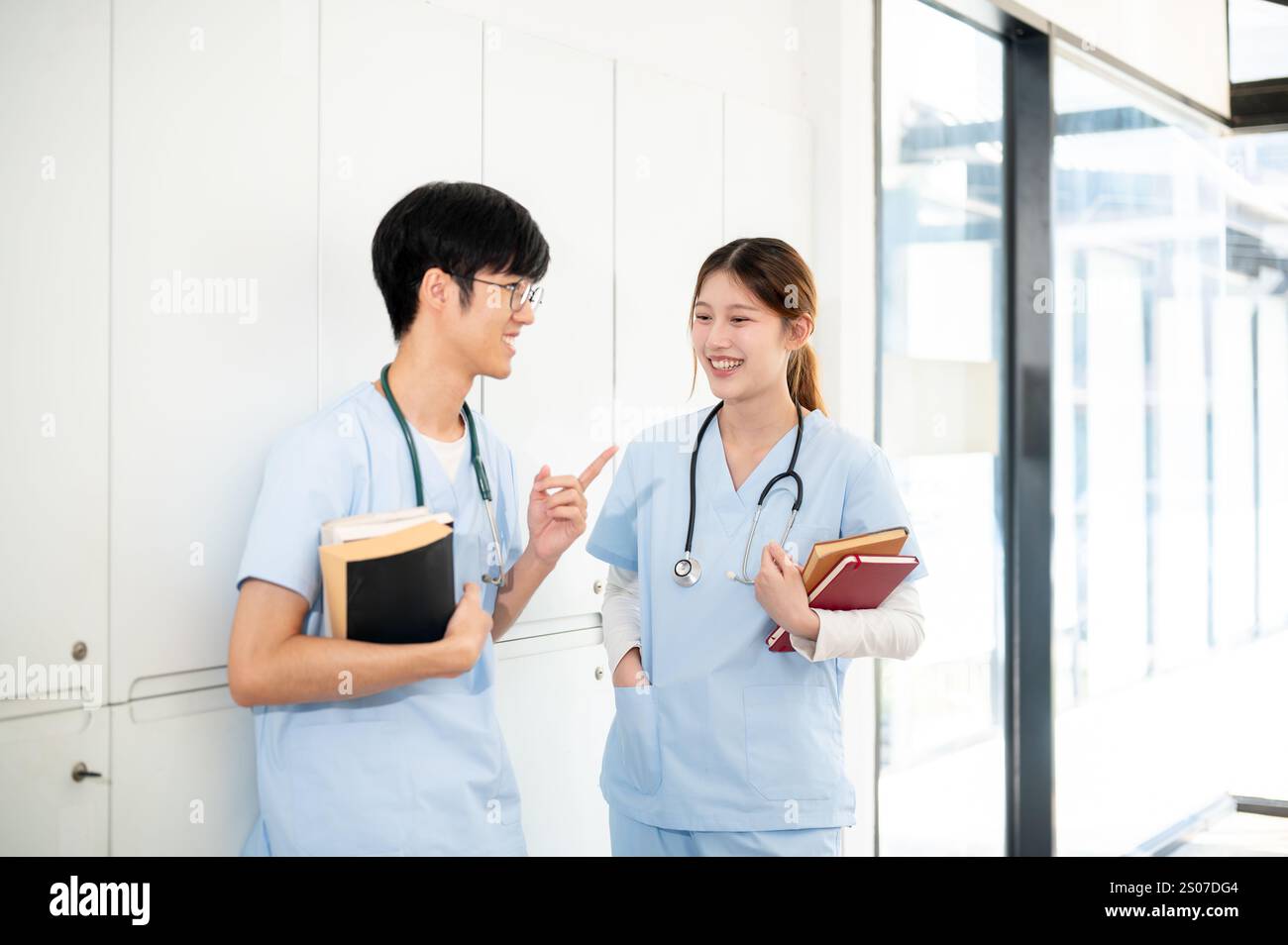 Two happy Asian male and female doctors or medical students are ...