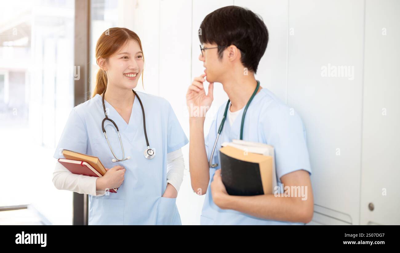Two happy Asian male and female doctors or medical students are ...