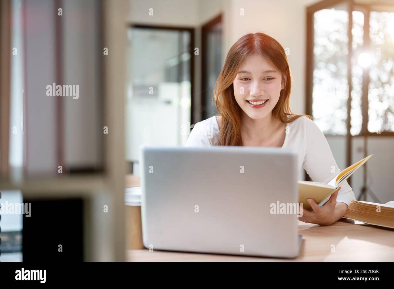 A beautiful, positive Asian female college student working remotely ...