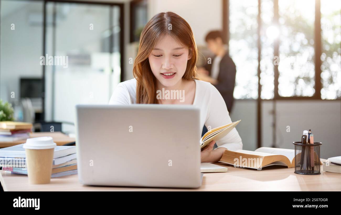 A beautiful, positive Asian female college student working remotely ...