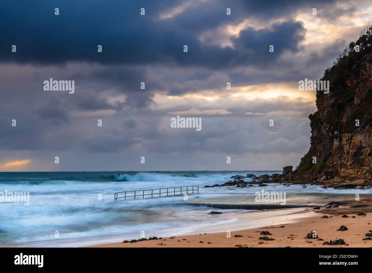 Rainy day sunrise with overcast sky and small waves at Macmasters Beach ...