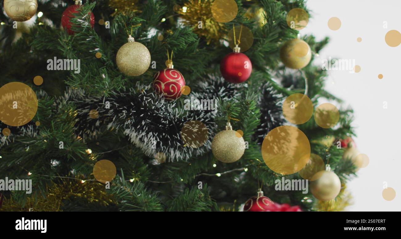 Christmas tree decorated with baubles, with a digital image of multiple ...