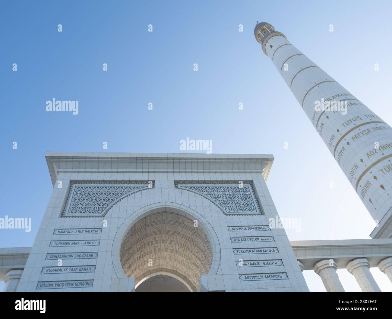The arched white marble main gate and a minaret at the Turkmenbashi ...