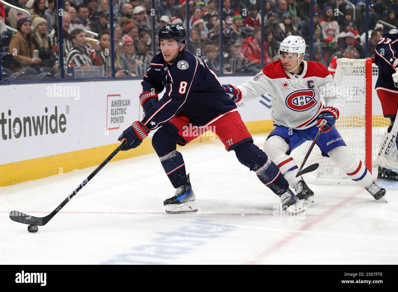 Columbus Blue Jackets defenseman Zach Werenski, left, controls the puck ...