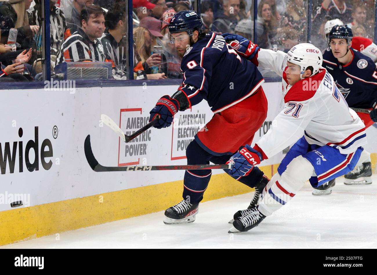 Columbus Blue Jackets defenseman Ivan Provorov, left, passes the puck ...
