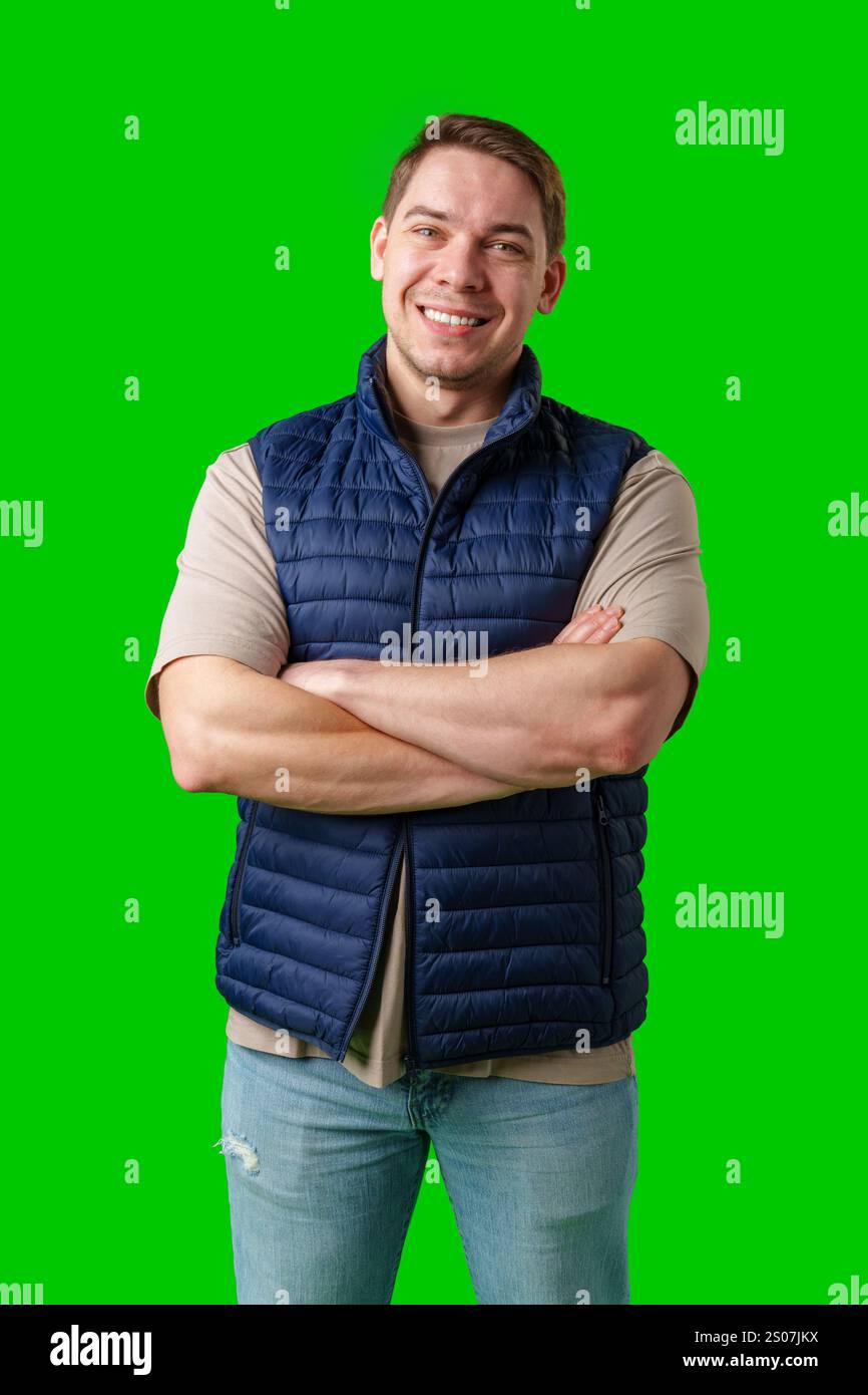 Confident man in a navy vest and t-shirt poses with crossed arms ...