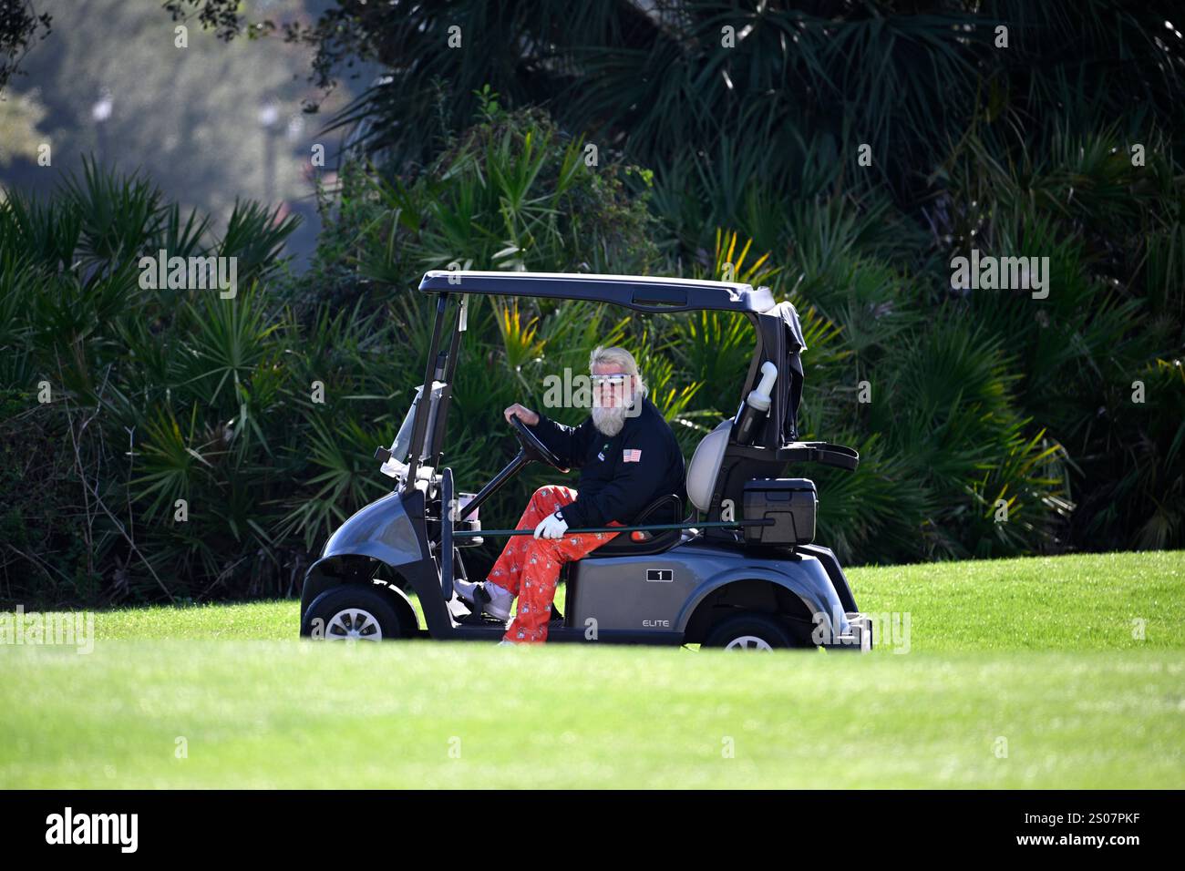 John Daly drives a cart to the third green during the first round of ...