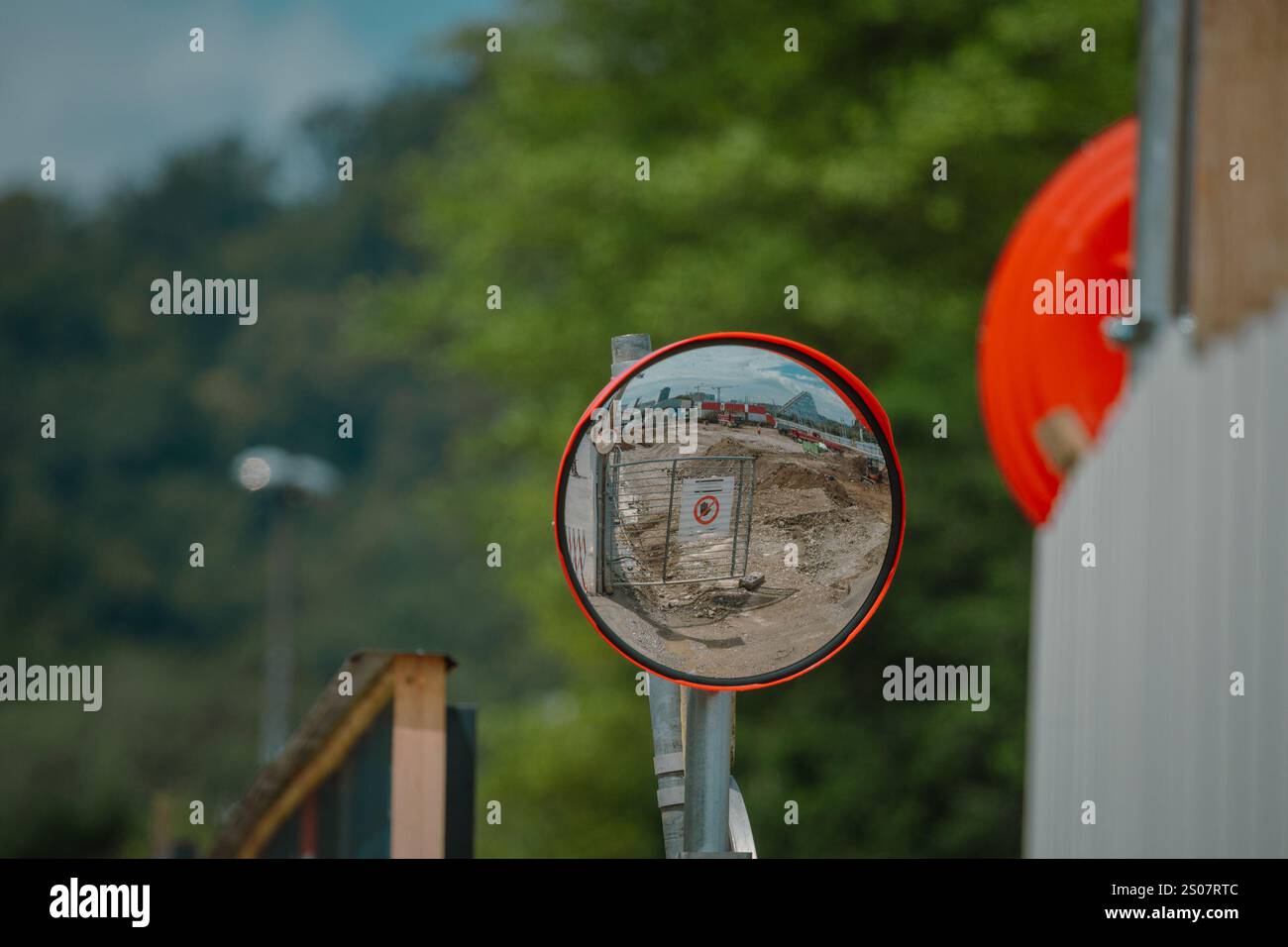 Round traffic mirror mounted high to help drivers view around the blind ...