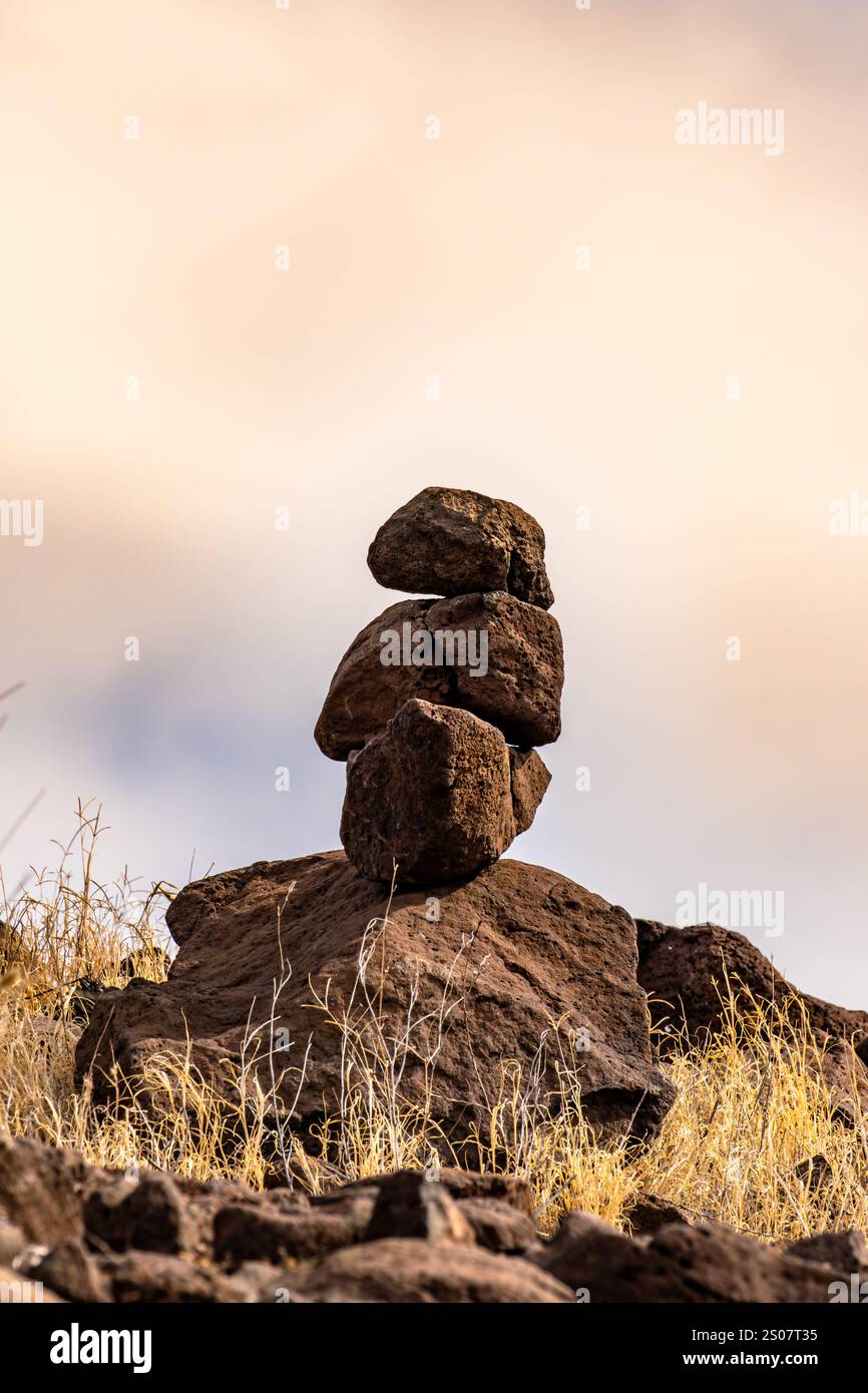 A rock formation is sitting on a hillside. The rocks are stacked in a ...