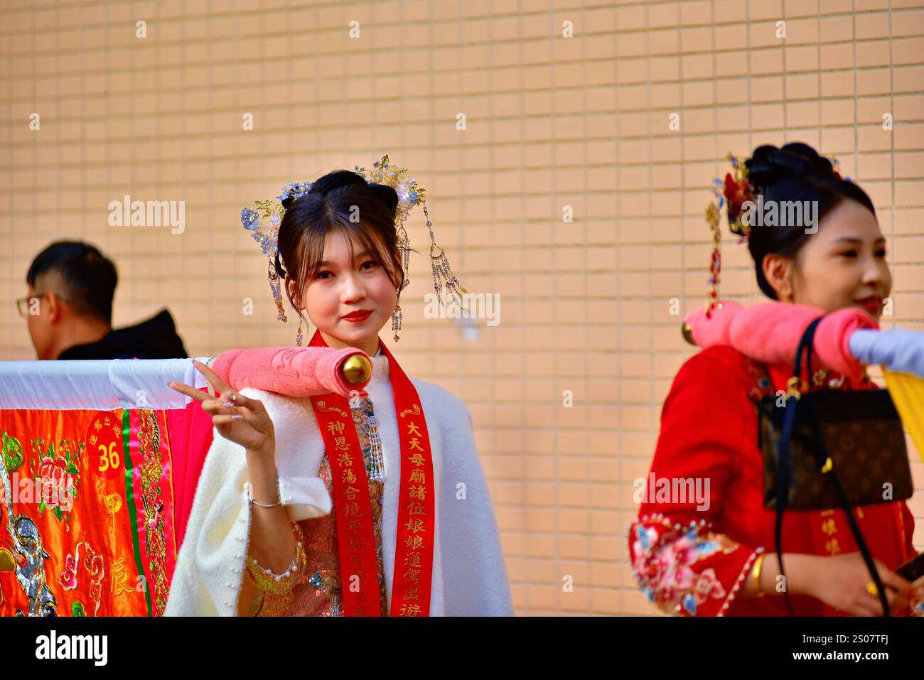 Young women bearing banners in traditional costumes in a colorful ...