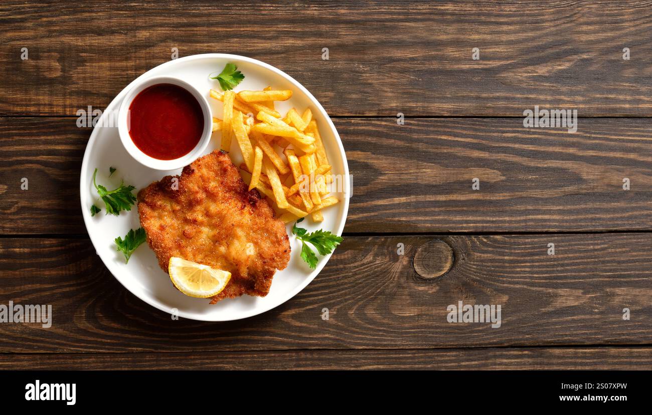 Homemade breaded weiner schnitzel with potato fries and sauce on white ...