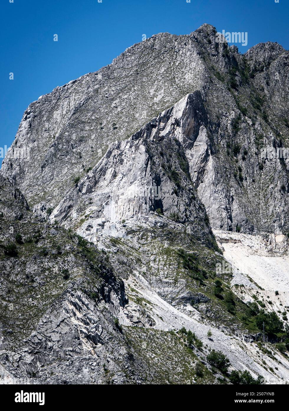 A rugged mountain landscape featuring steep rocky slopes and a clear ...