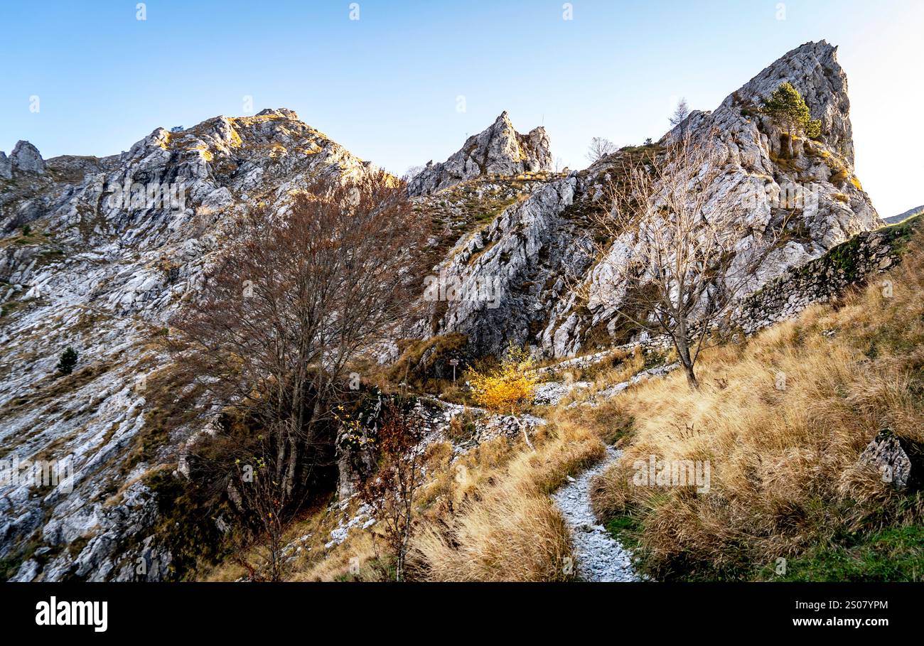 A scenic mountain landscape featuring rugged rocky peaks, a winding ...