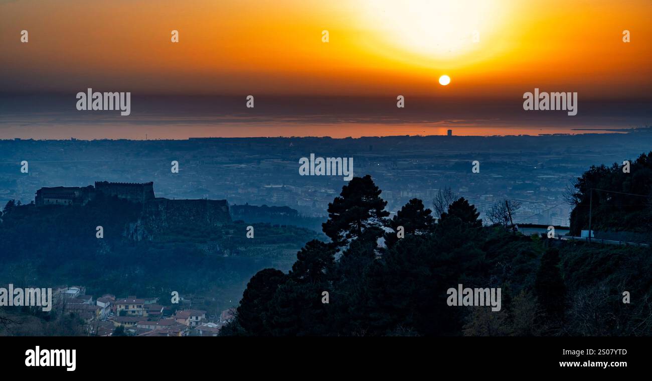 A breathtaking sunset view over a coastal city, with the sun dipping ...
