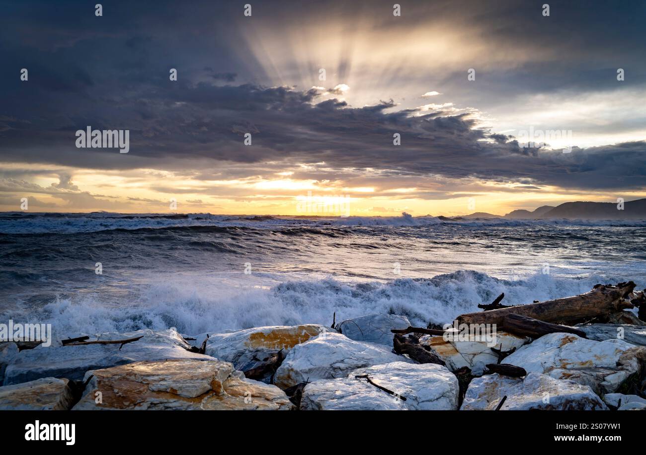 A dramatic seascape at sunset, featuring turbulent waves crashing ...