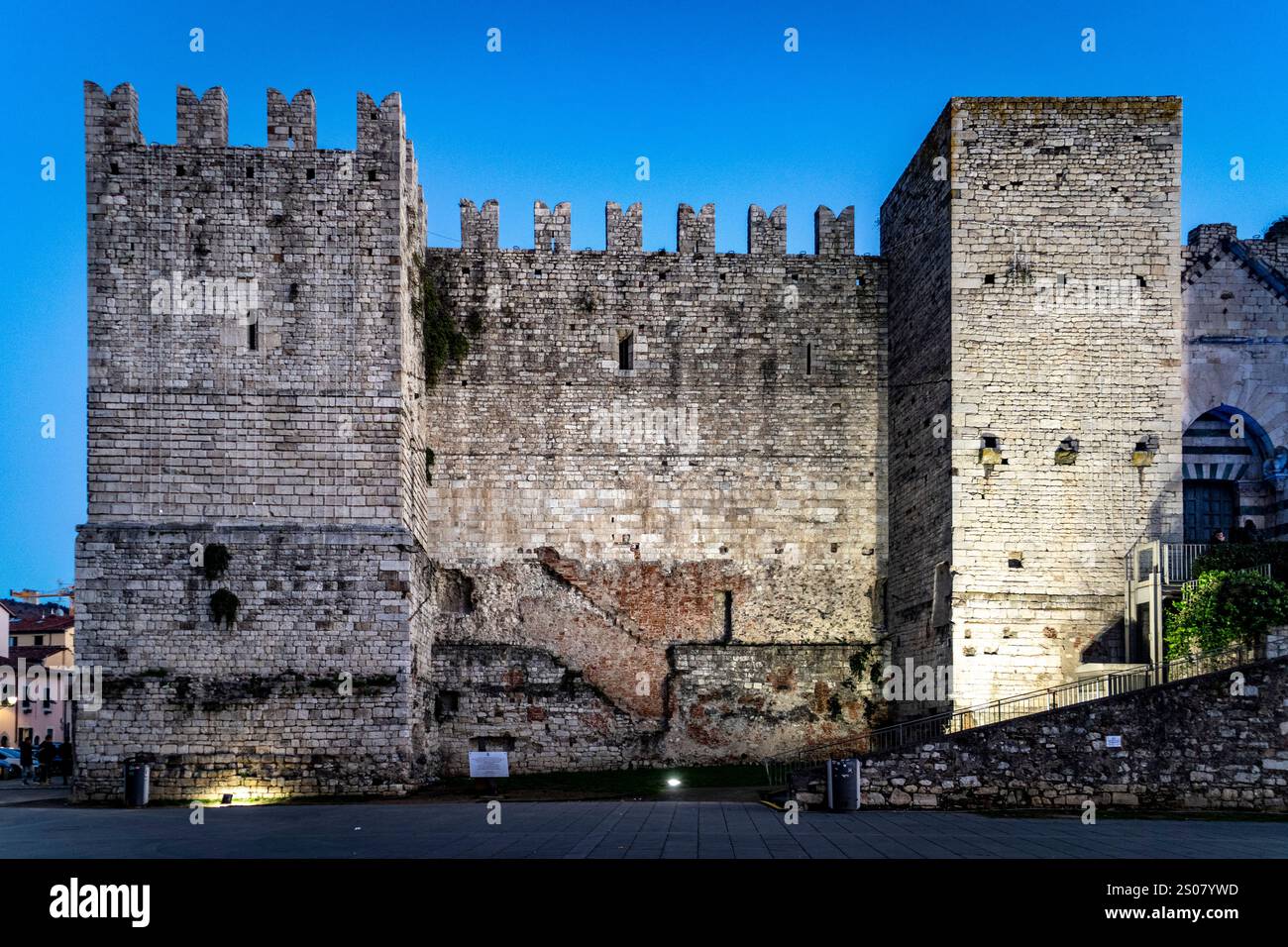 A historic stone fortress with tall walls and battlements, illuminated ...
