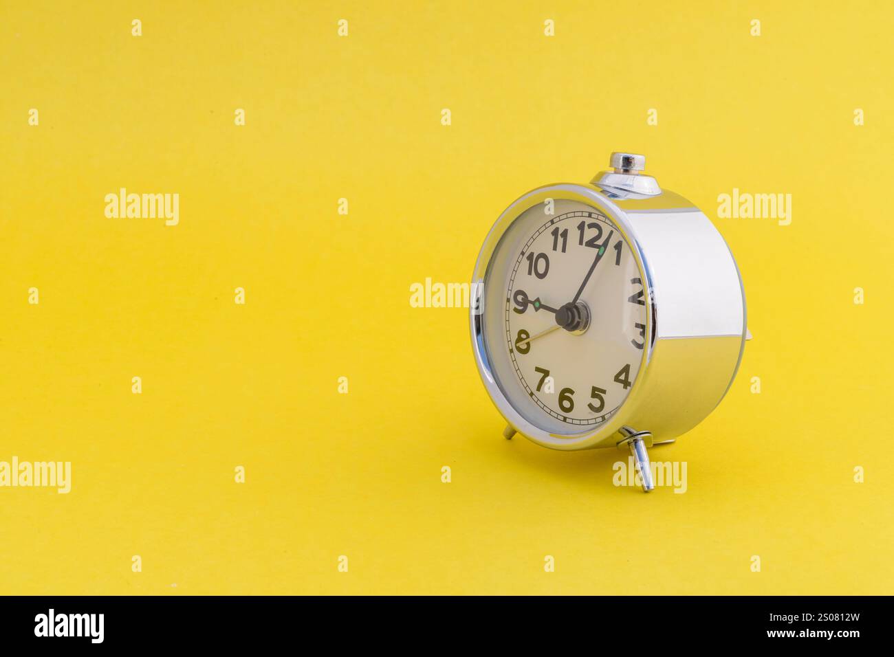 Vintage alarm clock on yellow color background. Blank space to add your ...