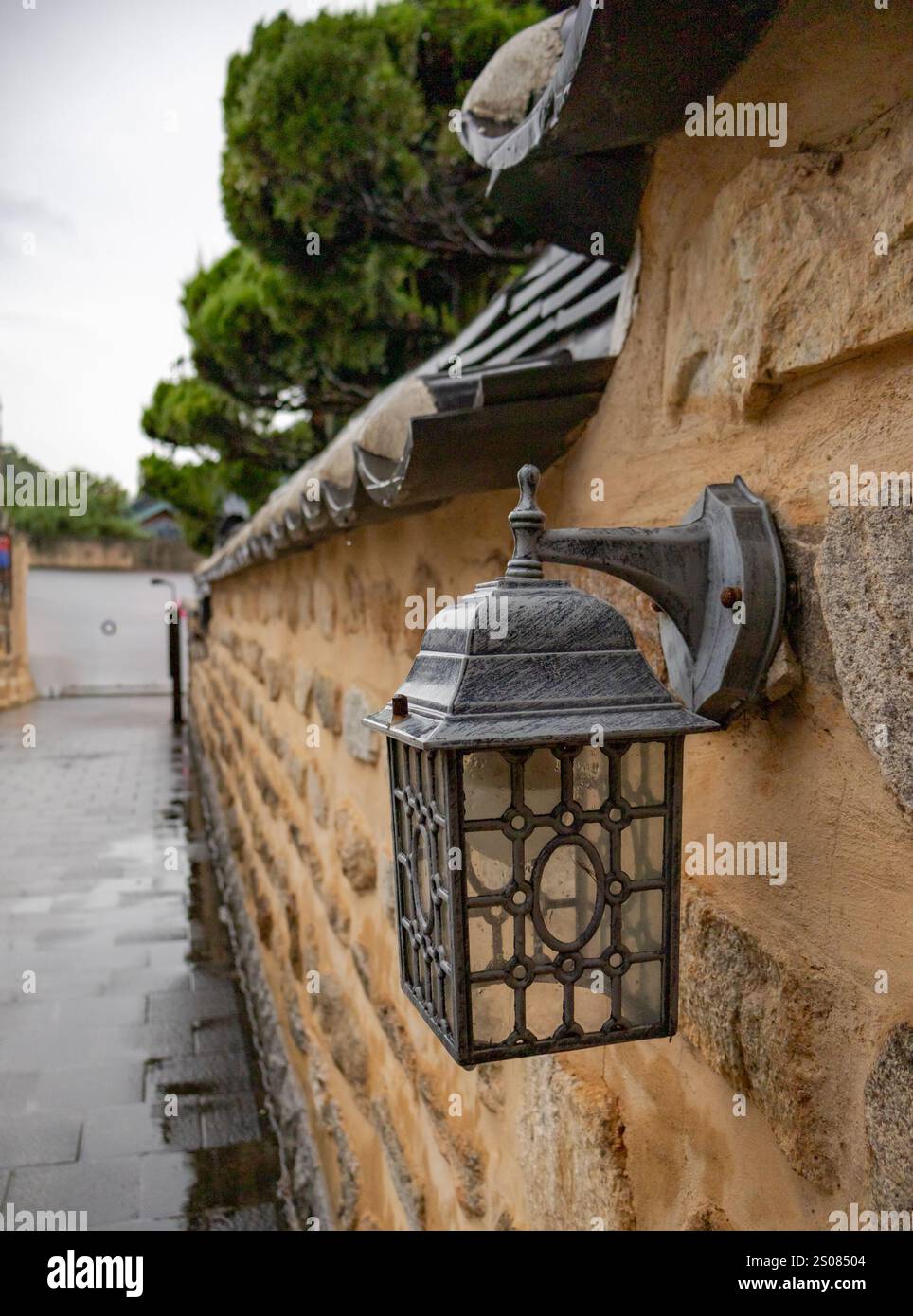 Old traditional metal lamp post on a stone brick wall. Photo taken in ...