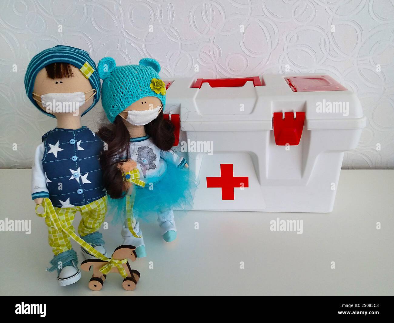 Two handmade dolls wearing protective masks are standing near a first ...