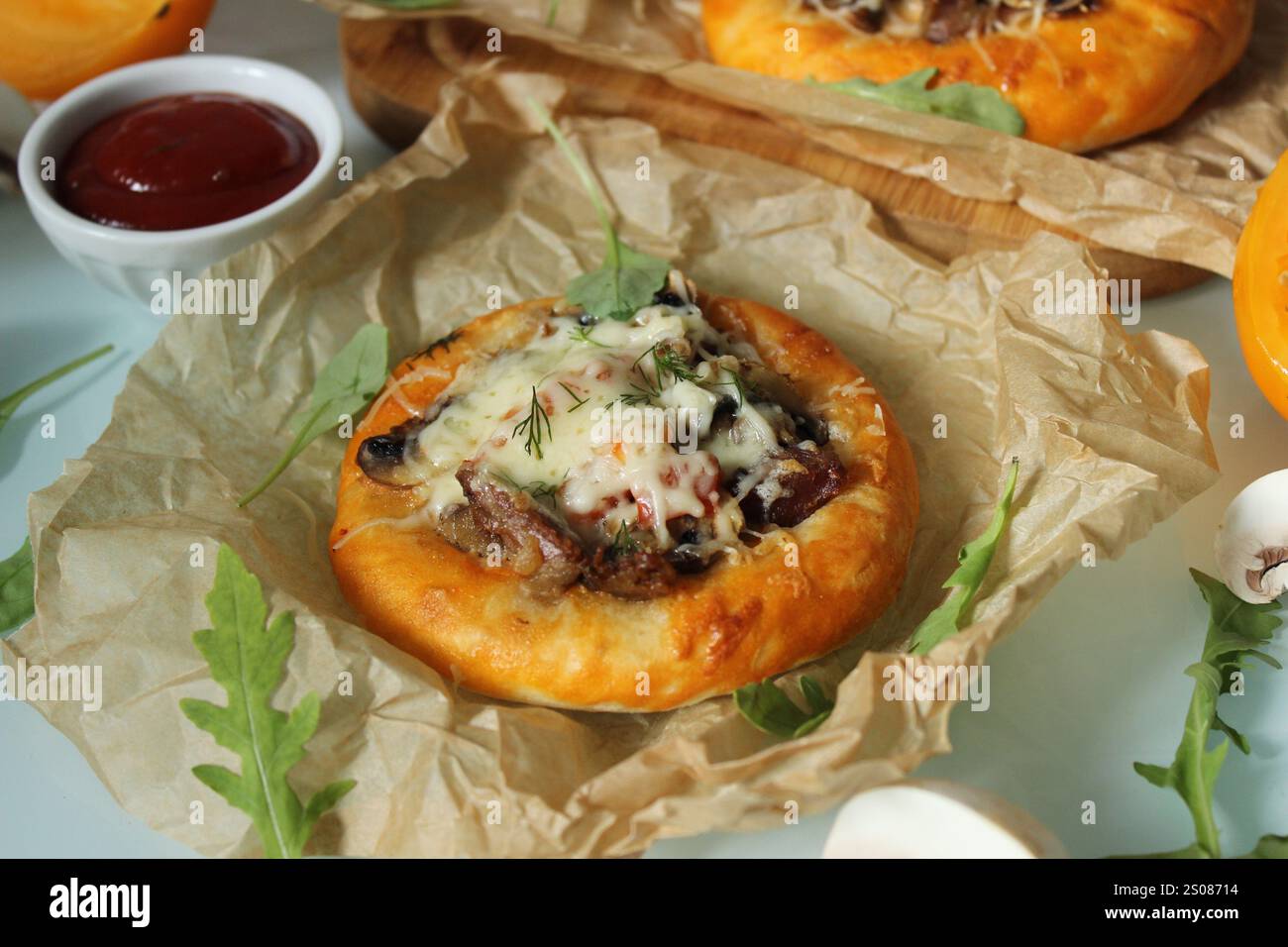 Delicious mini pizza with mushrooms, beef, melted cheese, and fresh ...