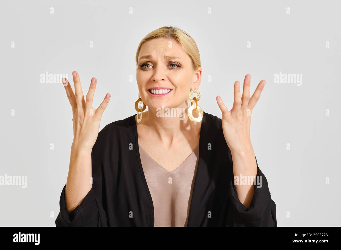 A blonde woman dressed in a stylish outfit shows visible signs of ...