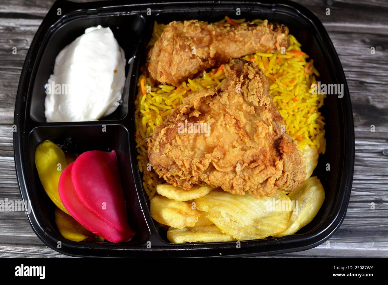 Broasted chicken meal with colorful Basmati rice, pickled slices of ...