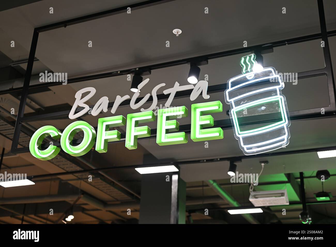Illuminated green and white Barista Coffee sign hanging from the ...