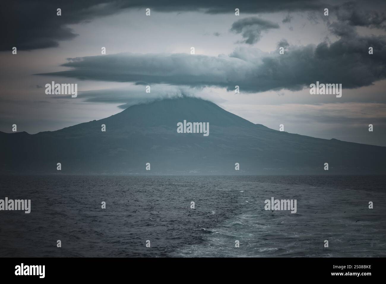 Pico volcano covered with clouds view from the ferry Pico island Azores ...