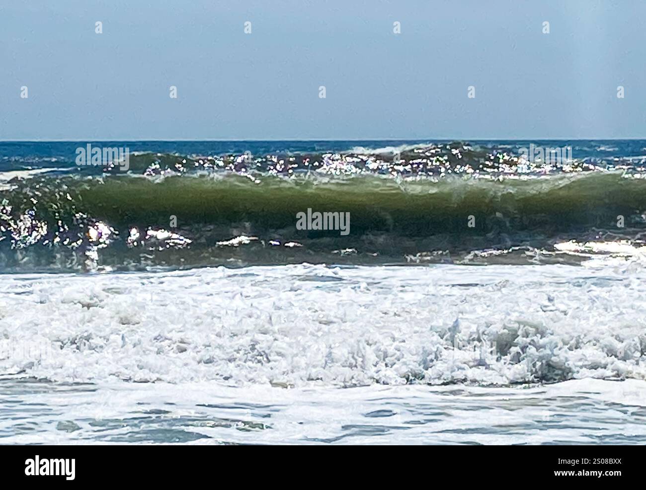 Bright colors and sunlight reveal vibrant waves crashing onto the shore ...