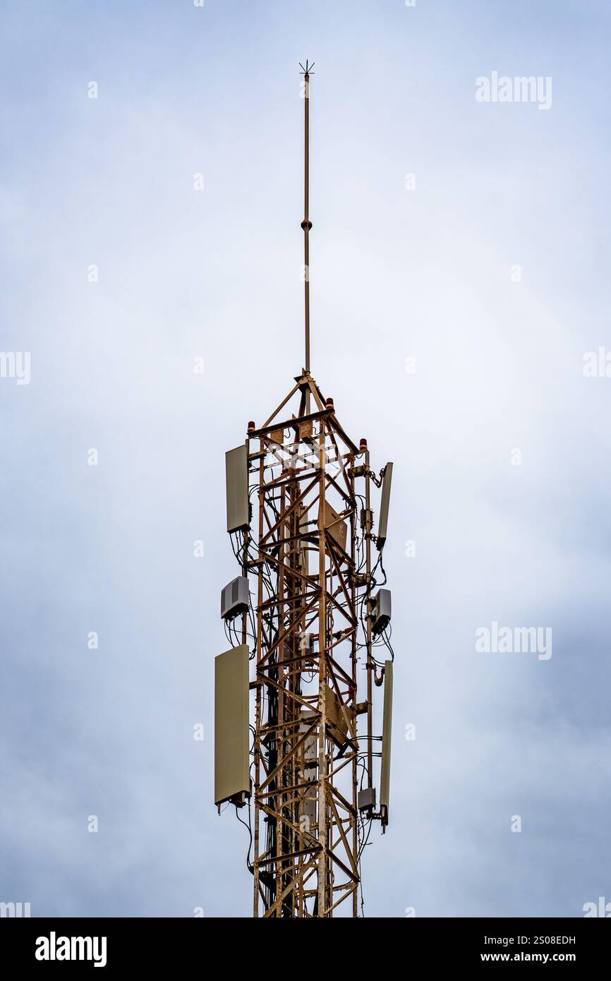 Communication tower with blue sky and clouds moving background. View of ...