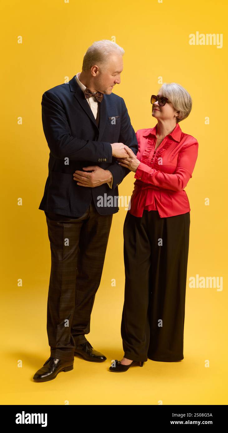 Couple exchanging smiles, man in formal wear leaning slightly toward ...