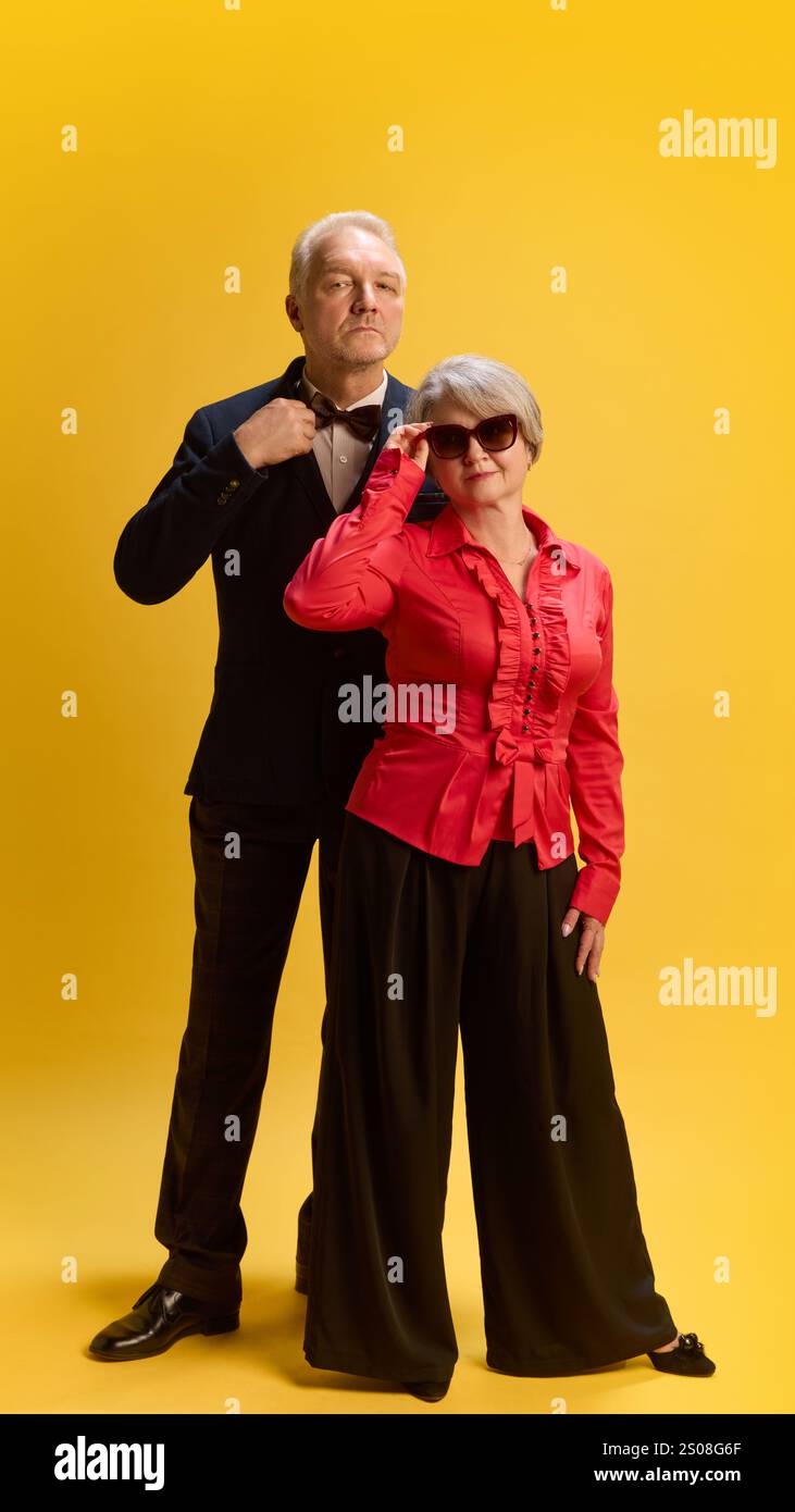 Sophisticated pair, man in tailored suit standing beside woman in ...