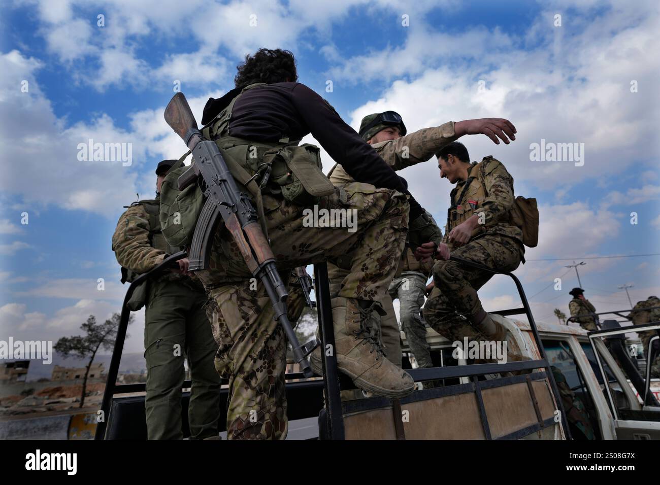 Syrian fighters travel on vehicles, as they patrol at a highway, in ...