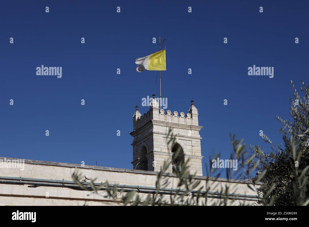 Yellow white flag of the Vatican flying over a tower on the roof the ...