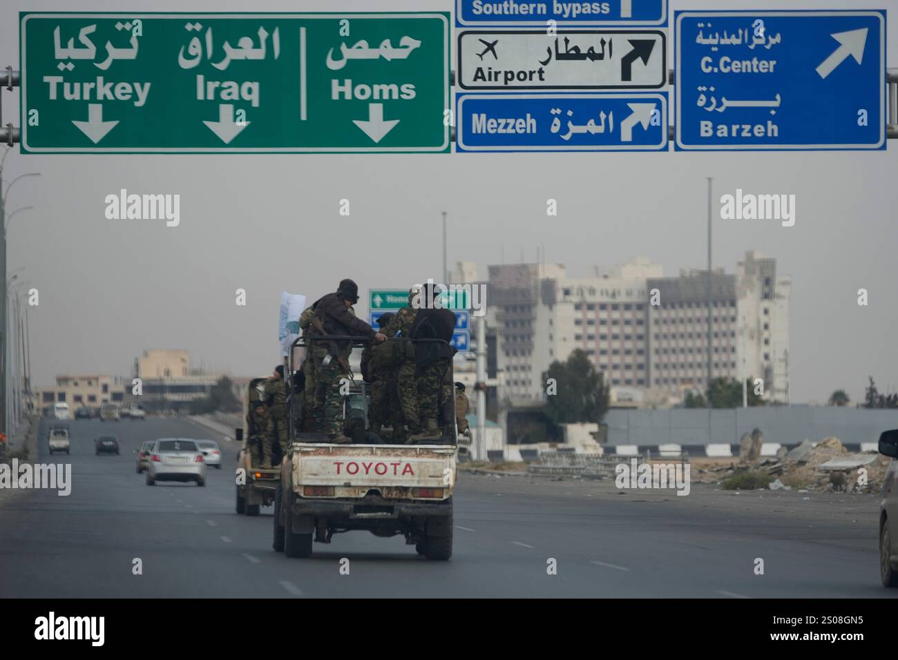 Syrian fighters travel on vehicles, as they patrol at a highway, in ...