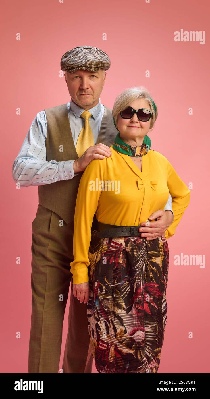 Mature man with serious expression rests hand on woman's shoulder ...