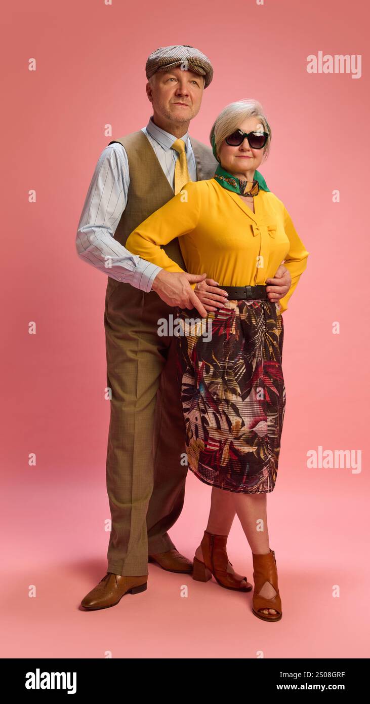 Man in beige suit holds woman by waist as she leans back slightly ...