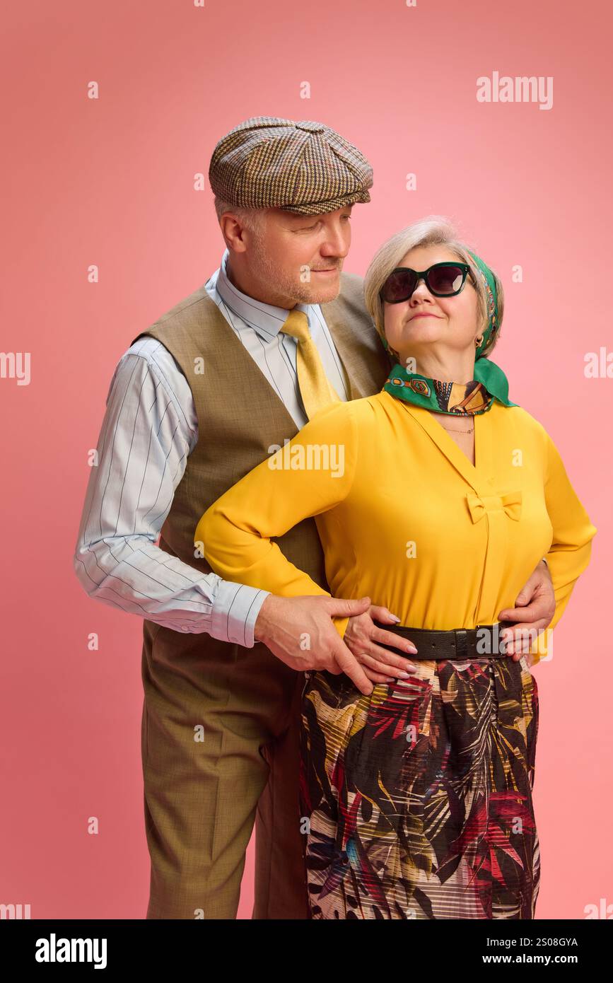 Portrait of mature couple. Man in beige suit holds woman by waist as ...