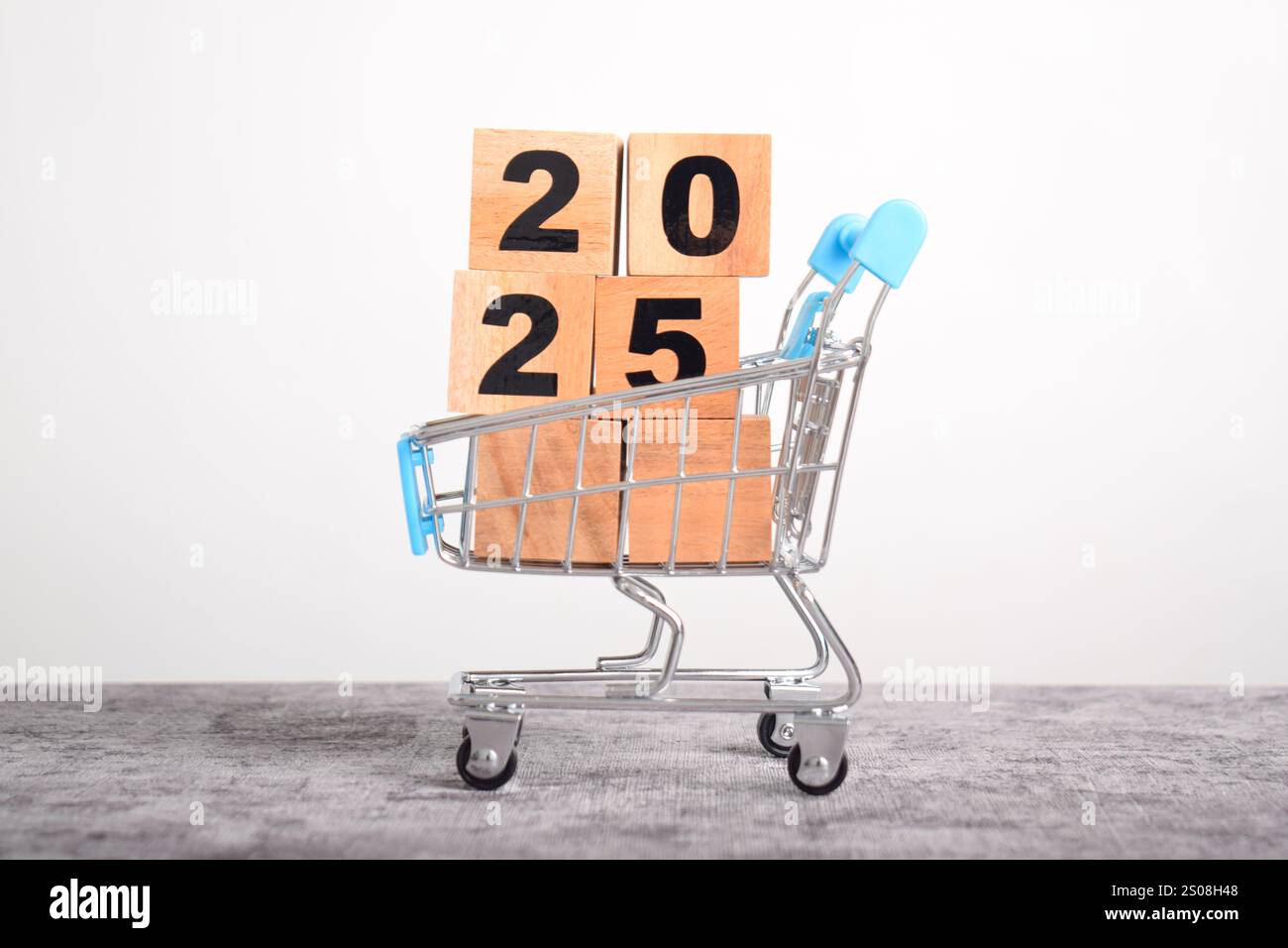 2025 wooden cube blocks in shopping trolley cart on table. E commerce ...